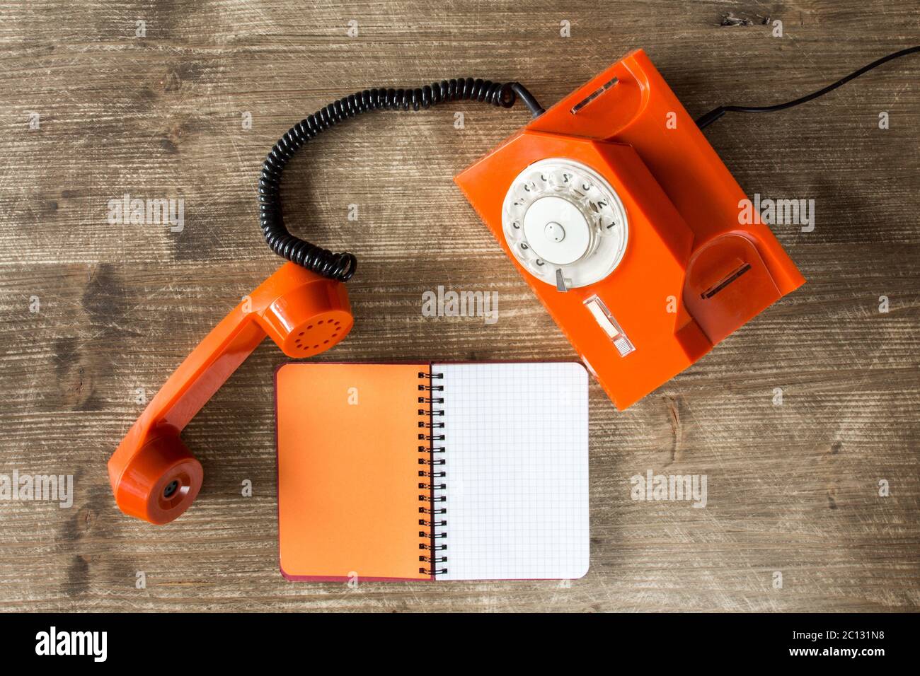 Old orange telephone and blank notebook Stock Photo - Alamy