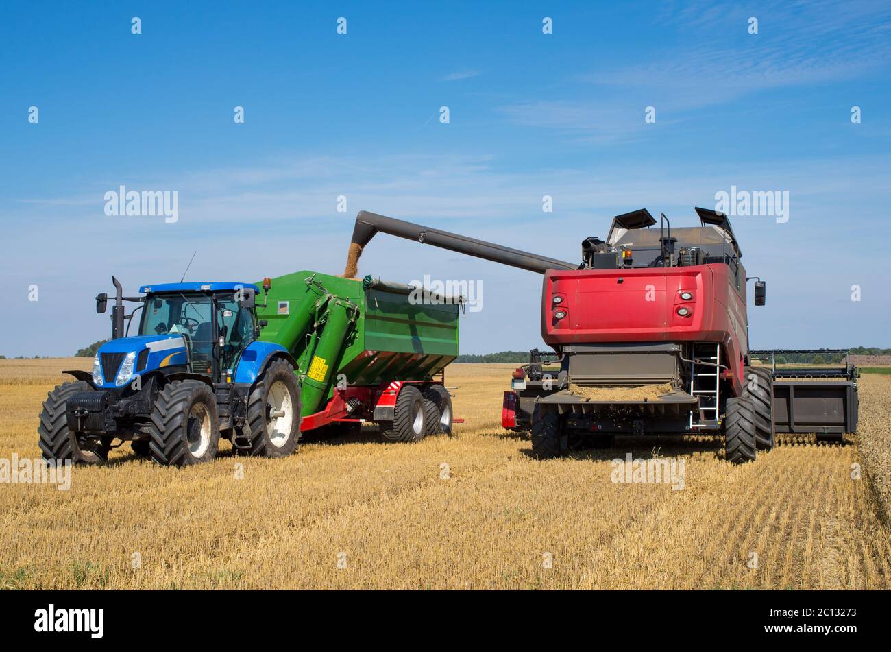 Harvest machine loading seeds in to trailer Stock Photo - Alamy