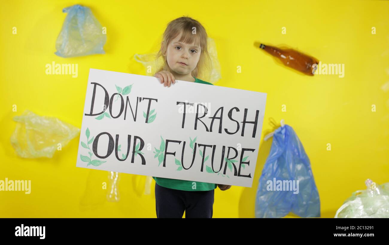Child girl activist in green t-shirt with recycle logo holds ...