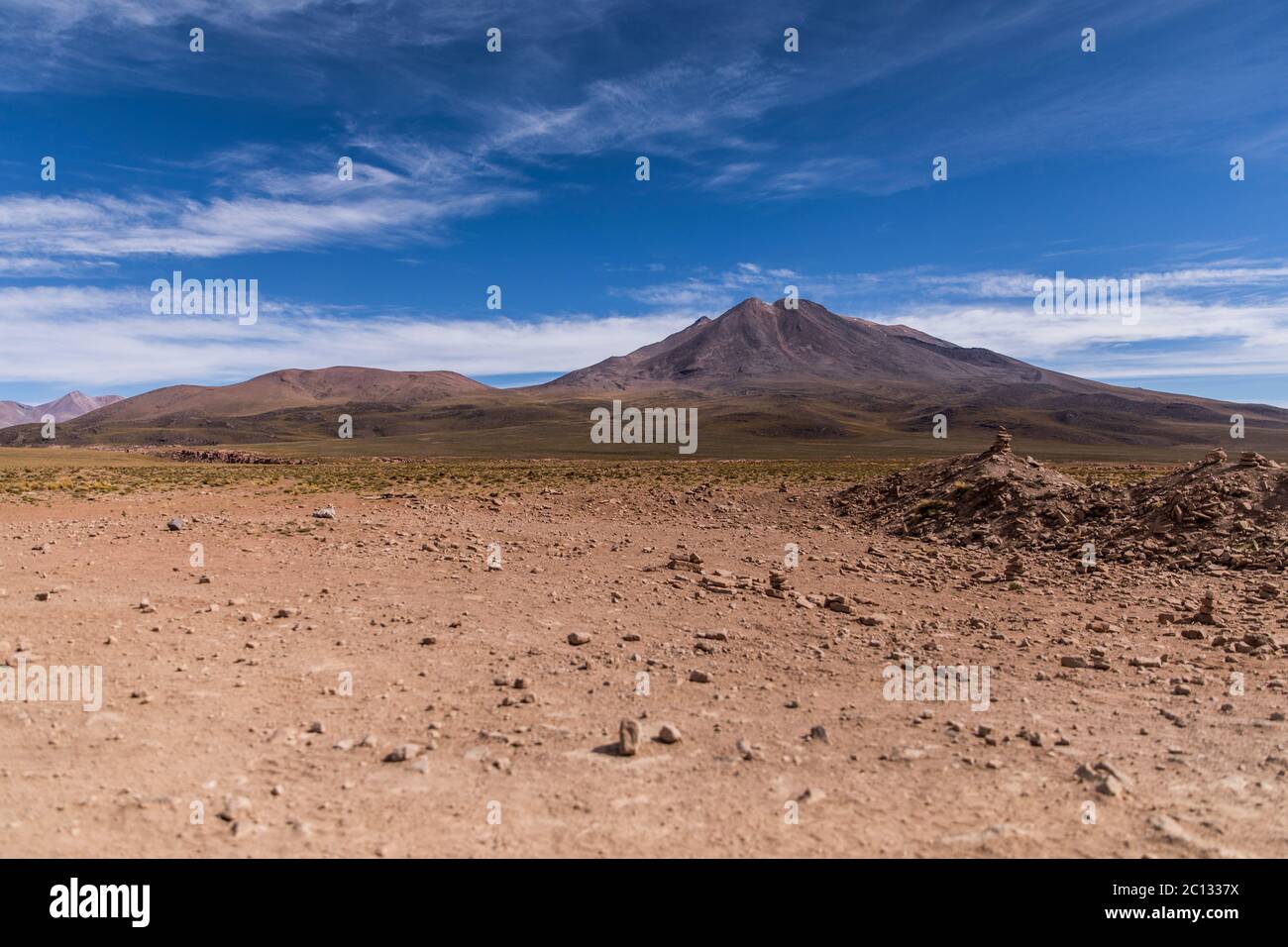 Landscape of a volcano in the desert with blue sky and some clouds in ...