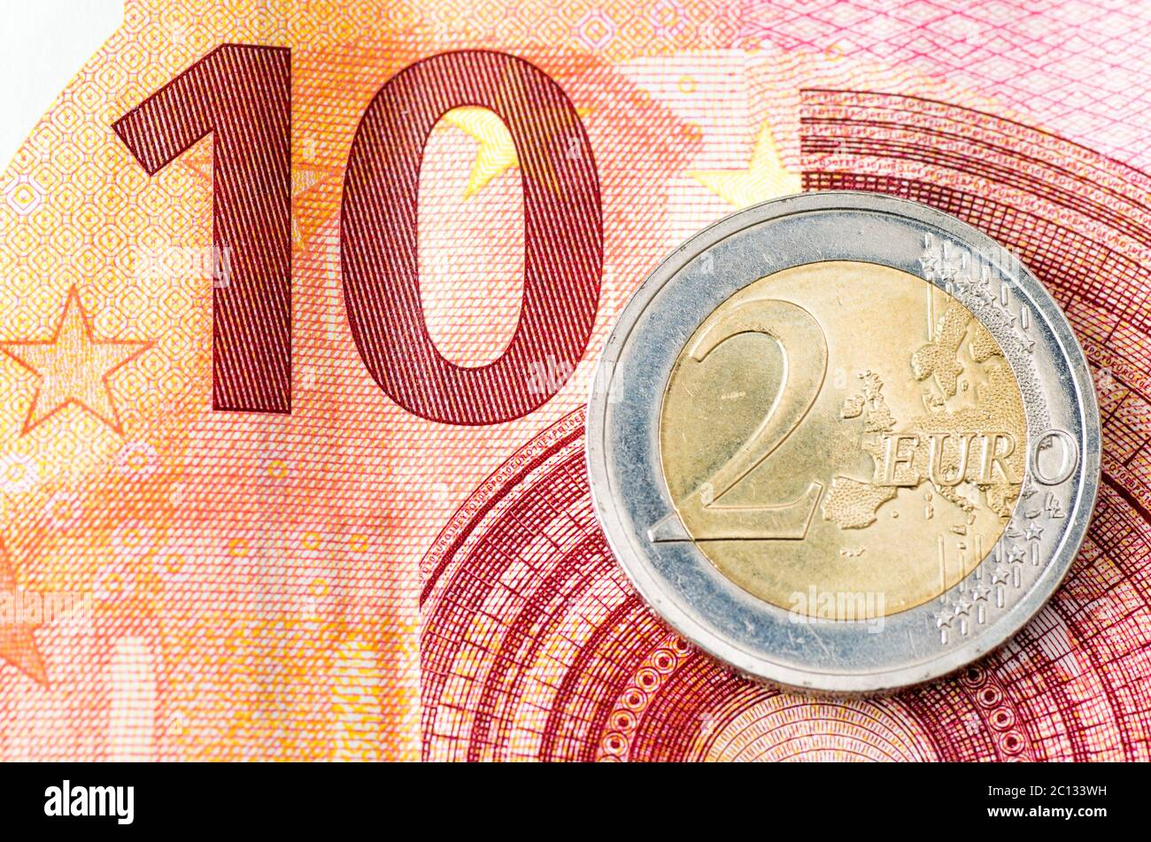 Detail of two euro coin on red ten euro banknote background Stock Photo ...