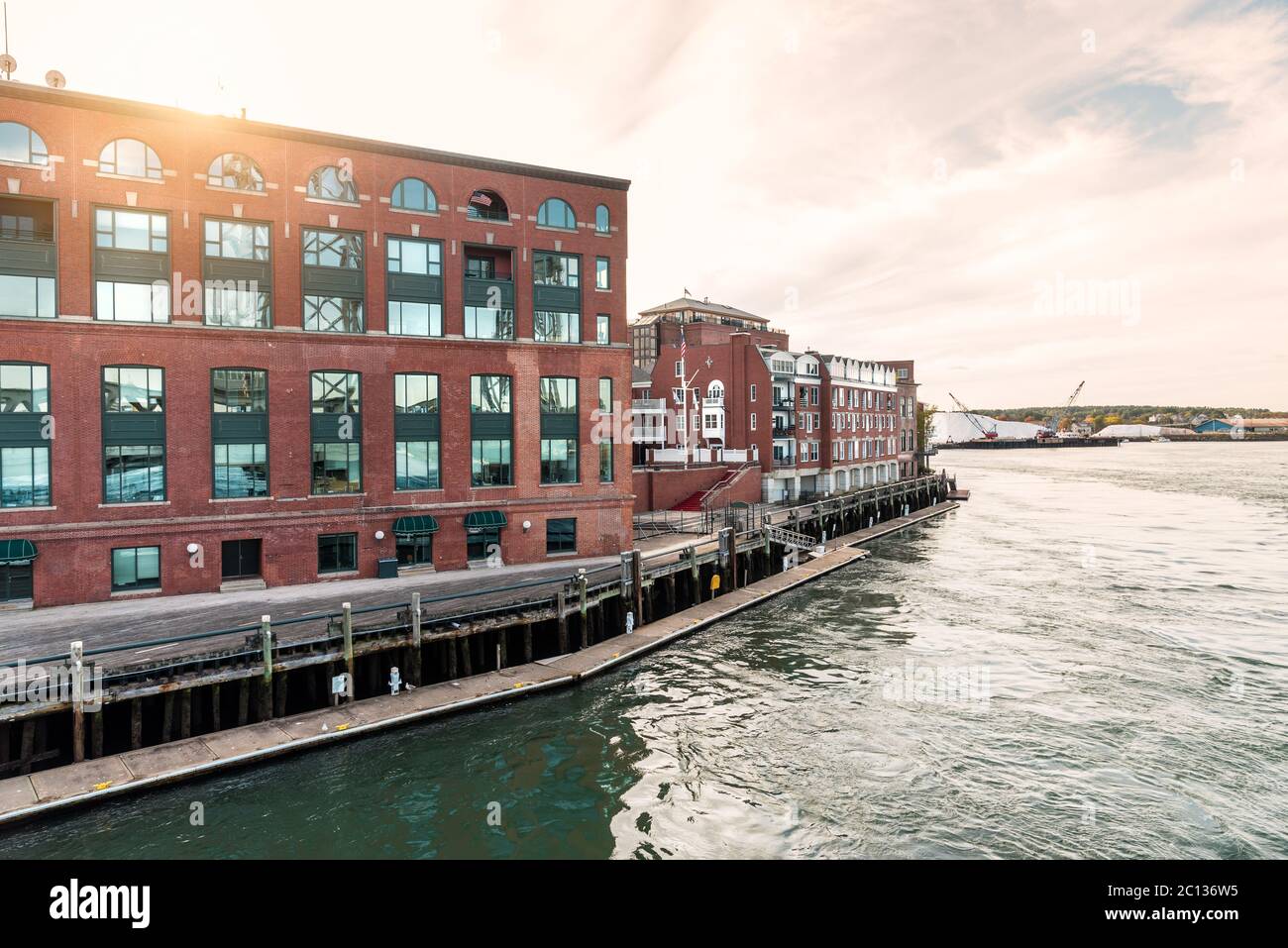 Autumnal sunset over historic riverside brick warehouses converted into ...