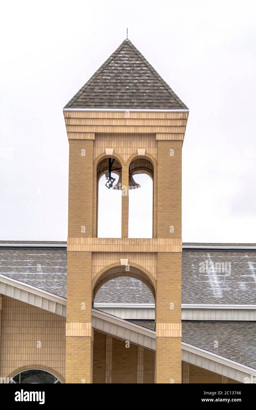 Modern belfry tower of a religious building with roof and cloudy sky ...