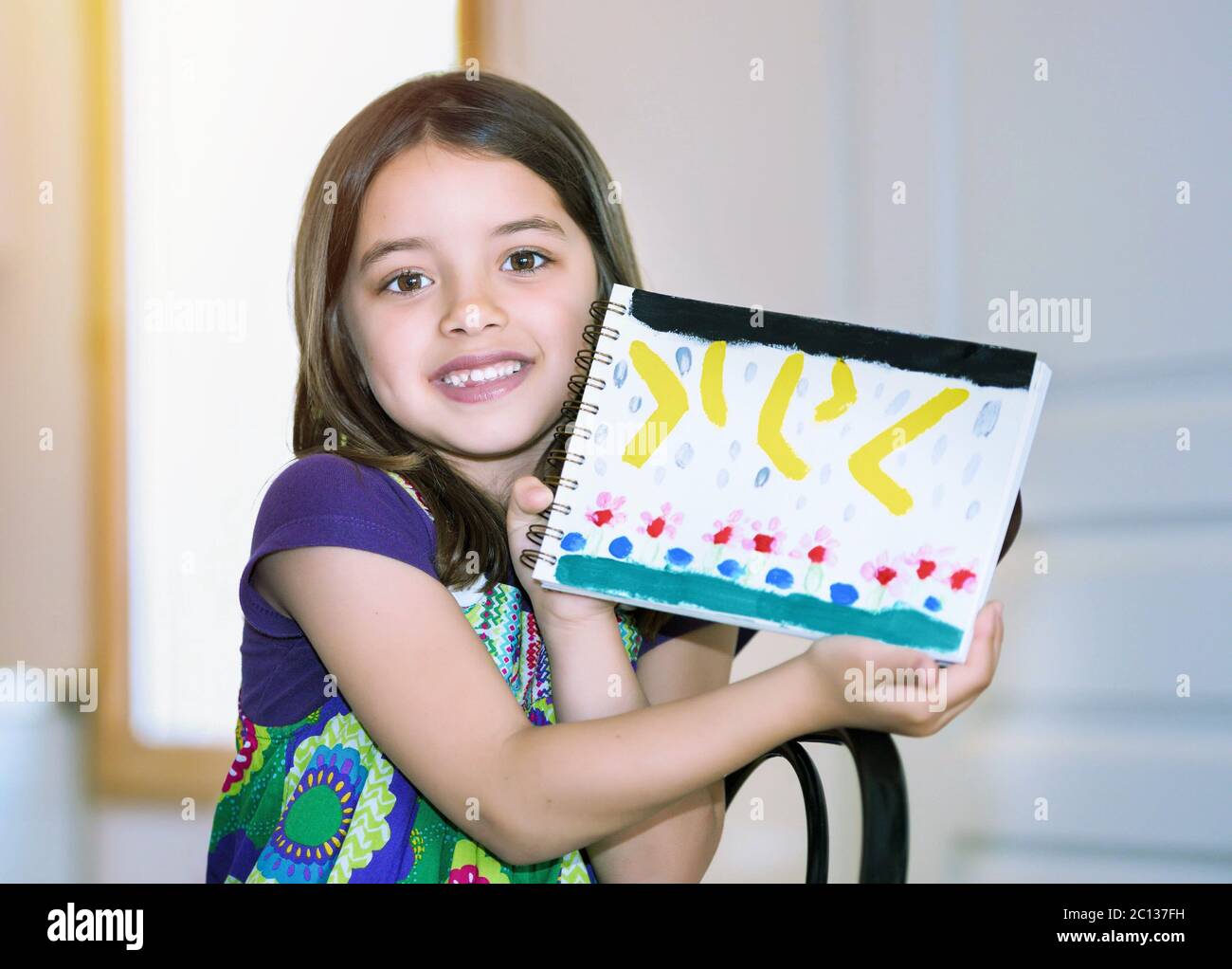 Portrait of a beautiful girl showing her drawing Stock Photo - Alamy