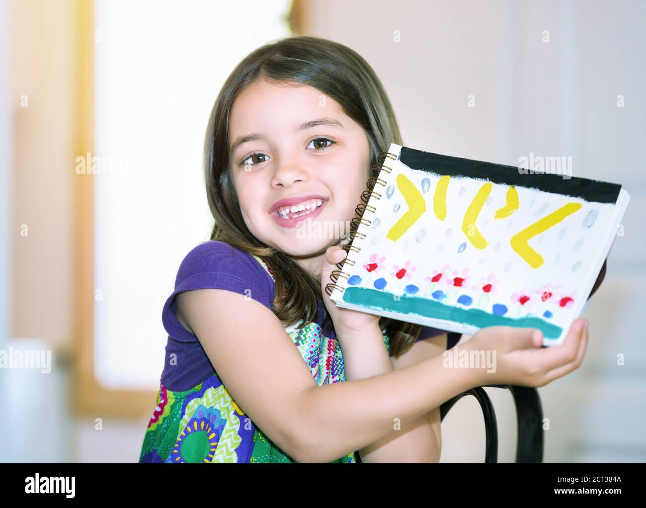 Portrait of a beautiful girl showing her drawing Stock Photo - Alamy