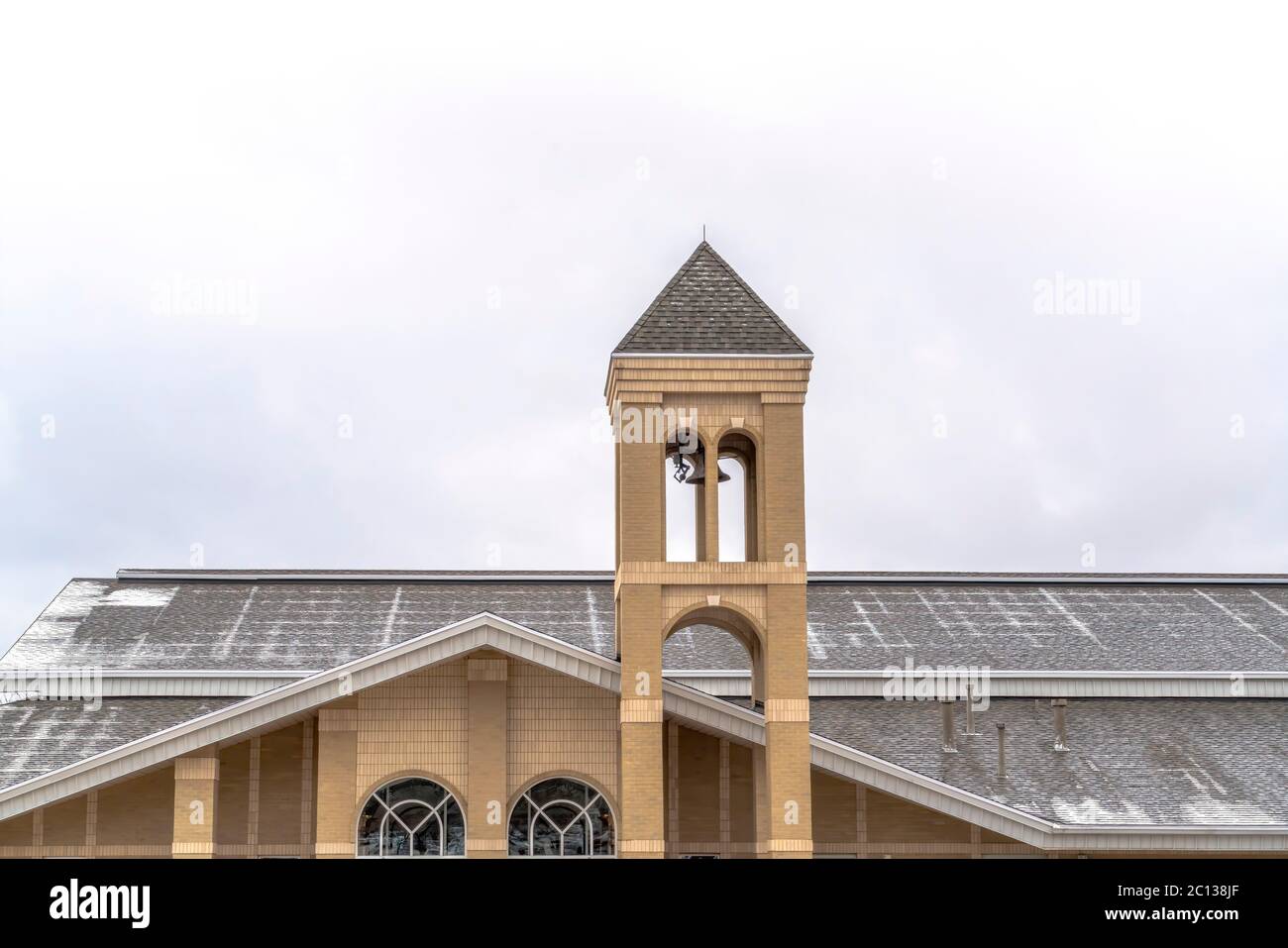 The belfry tower and roof of a church with cloudy sky view in the ...