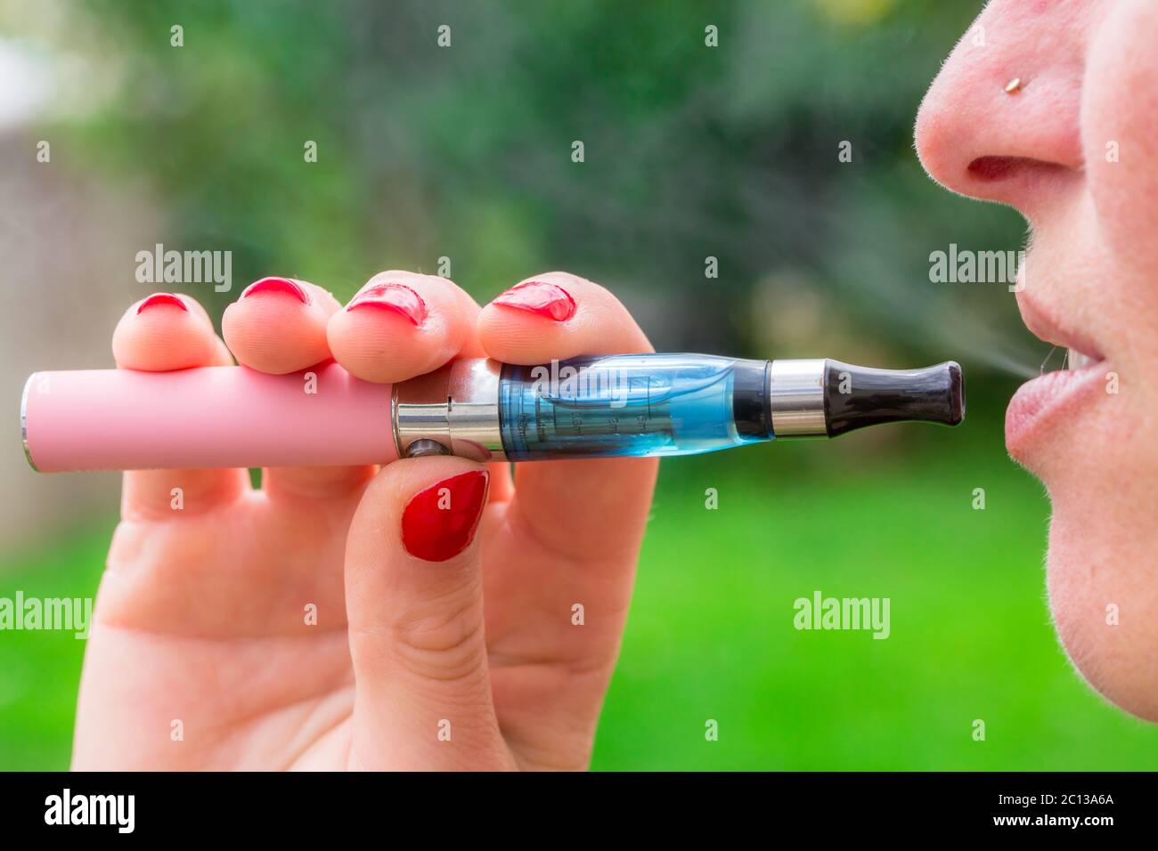 A woman inhaling from an electronic cigarette Stock Photo - Alamy