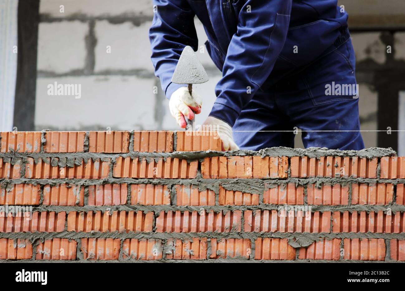 professional construction worker laying bricks and building house on ...