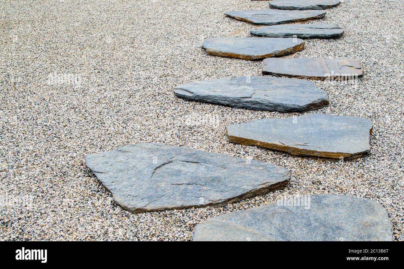 flat stones along a gravel pathway in a Japanese garden with copy space ...