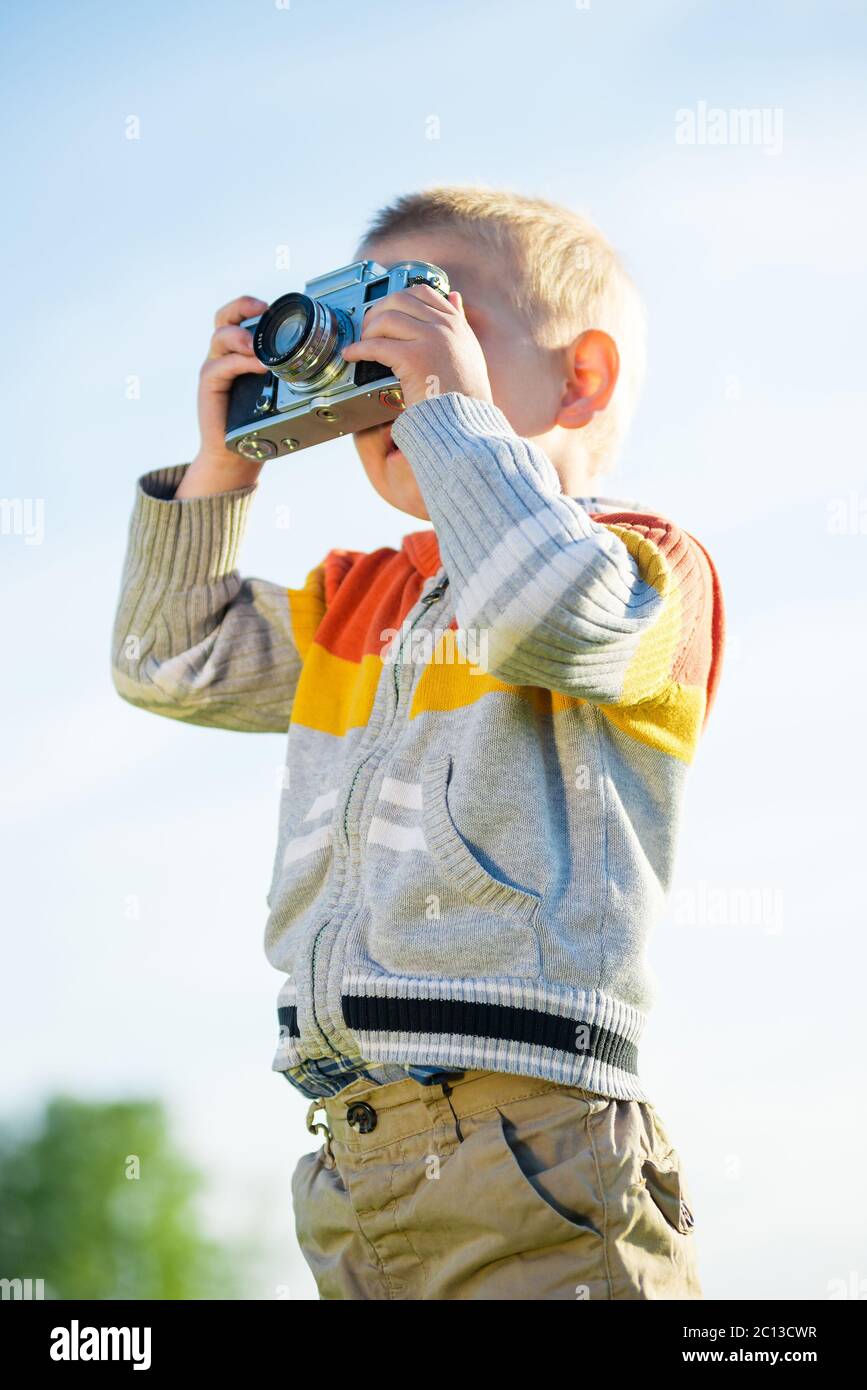Little boy with an old camera shooting outdoor Stock Photo - Alamy