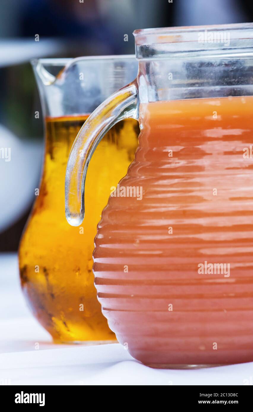 colorful pitchers of sangria, cider and grapefruit juice on a table ...