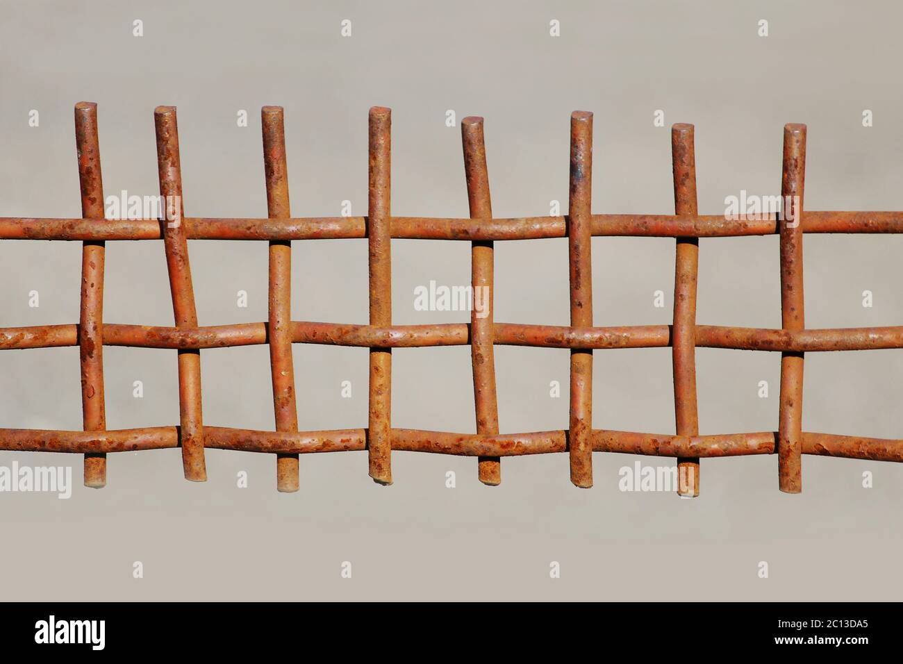 rusty metal fence on a grey background Stock Photo - Alamy