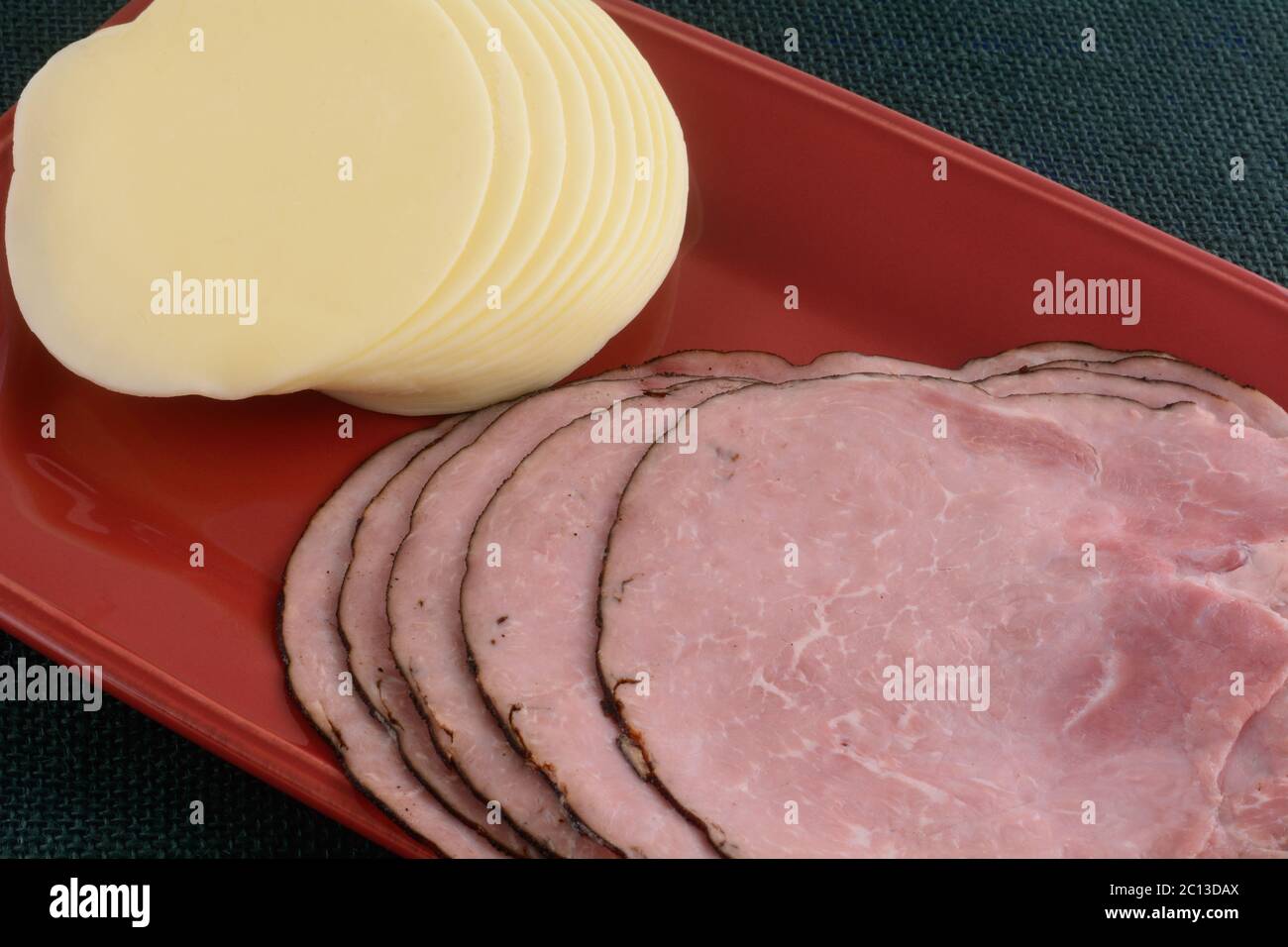 Stacks of black forest ham and provolone cheese scold cut slices on red ...