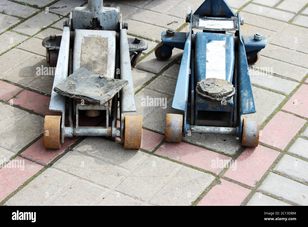 two working jack for repairing cars on the background of paving slabs ...
