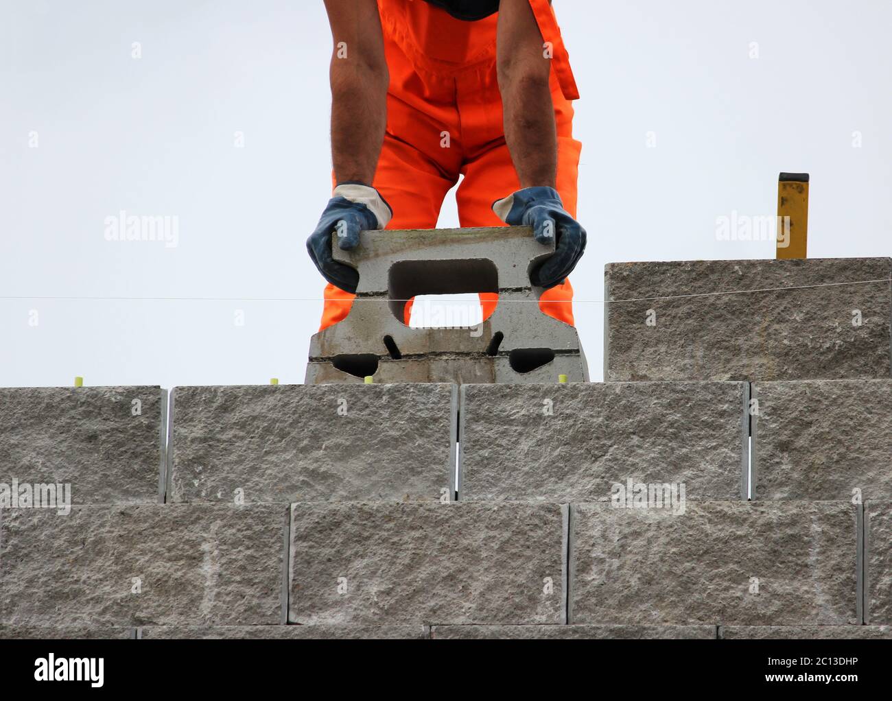 Bricklayer putting down another row of bricks in site during the ...