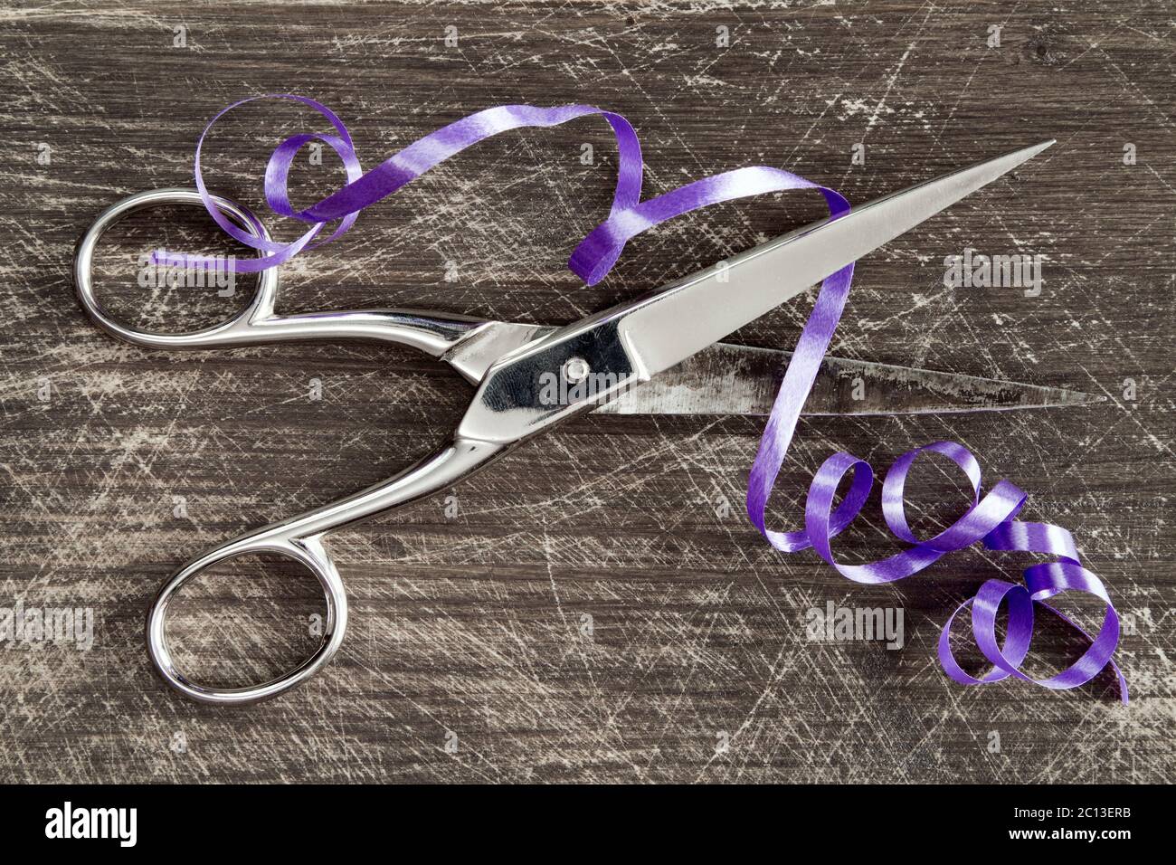 Iron scissors cutting the purple ribbon Stock Photo - Alamy