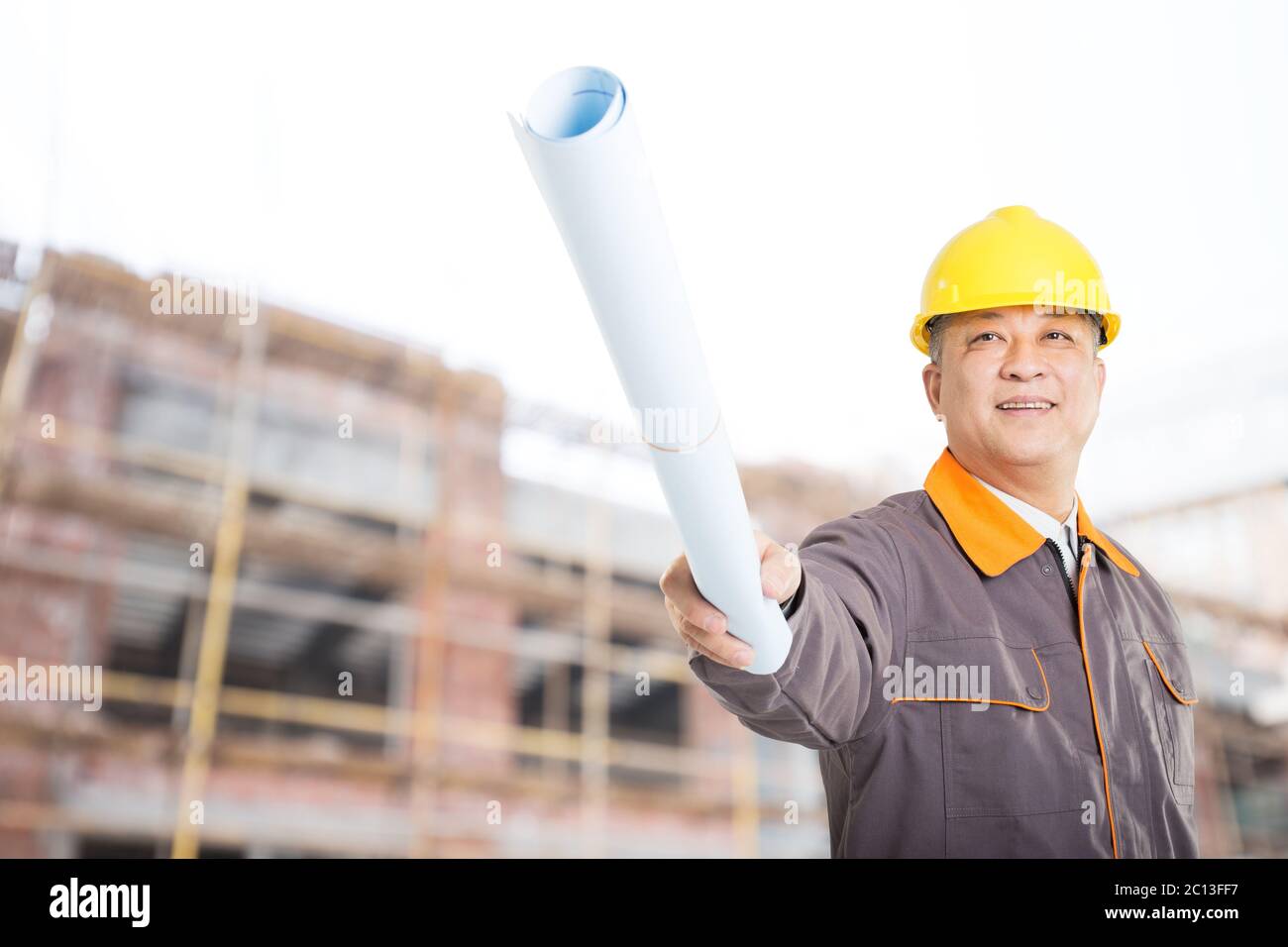 old asian man engineer with blueprint and new construction site Stock ...