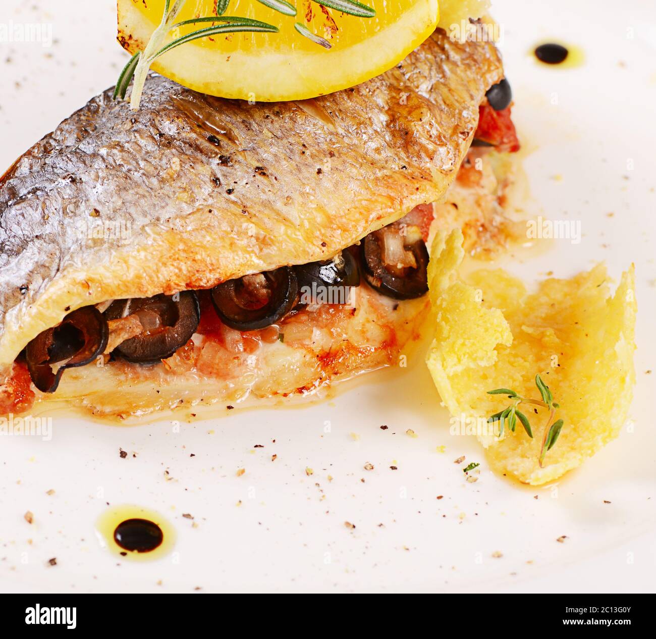 Baked fish stuffed with olives Stock Photo - Alamy