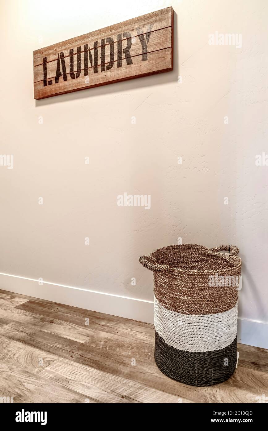Laundry room interior with woven basket and decorative wooden sign ...