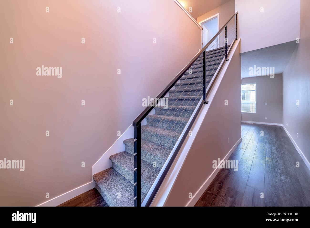Indoor staircase against brown wooden floor and plain white wall of ...