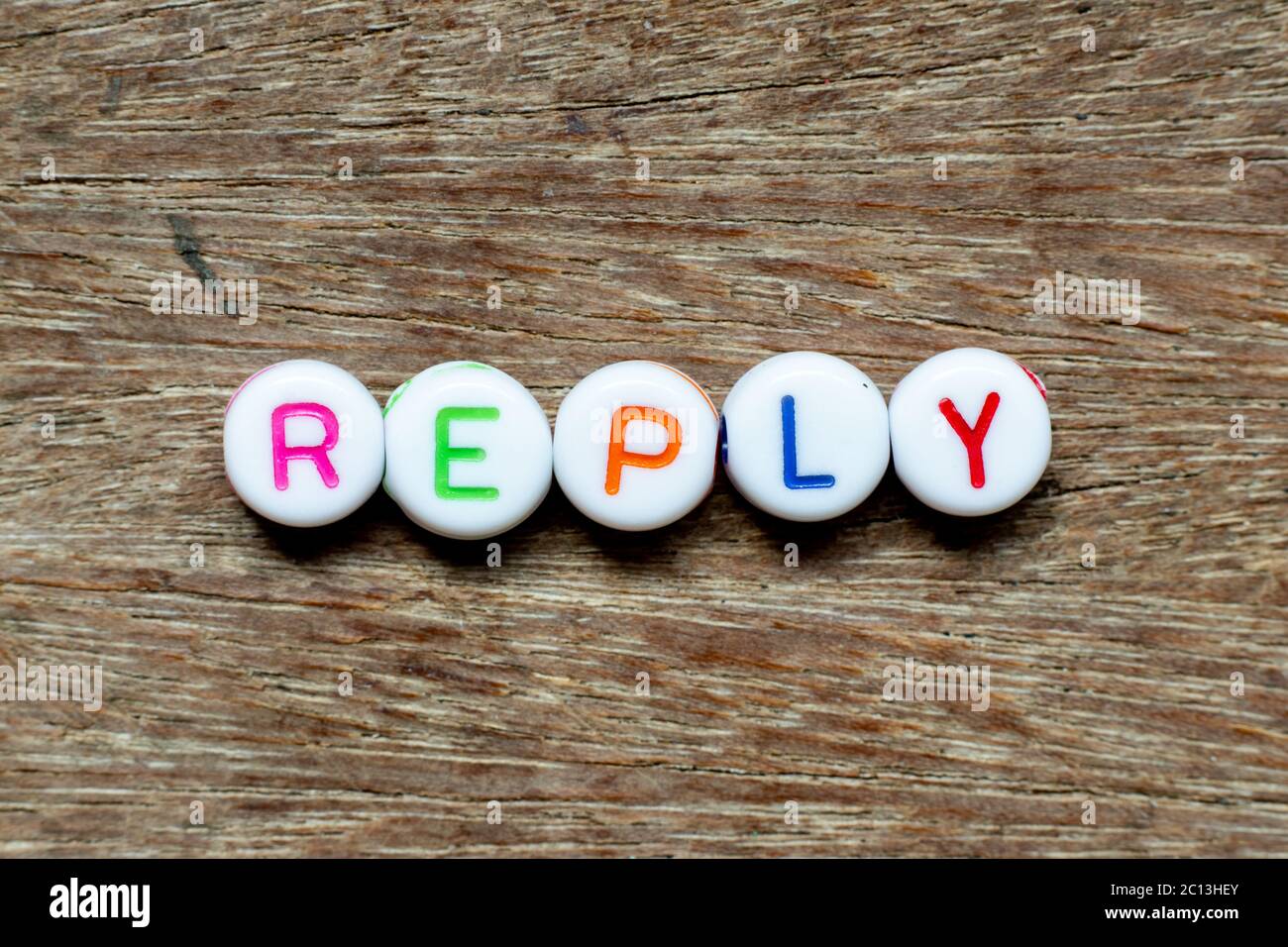 White bead with color letter in word reply on wood background Stock ...