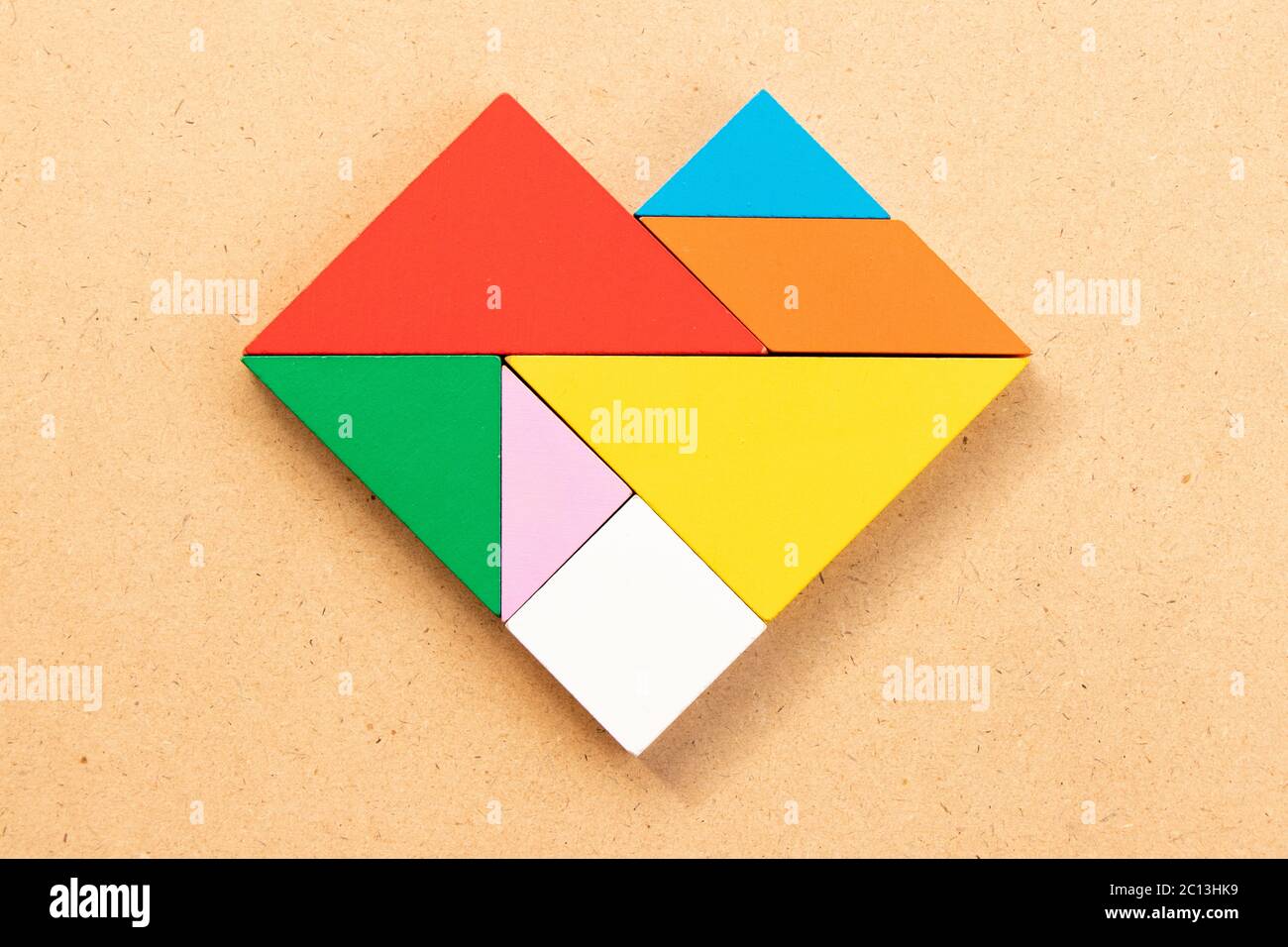 Color tangram puzzle in heart shape on wood bacground Stock Photo - Alamy