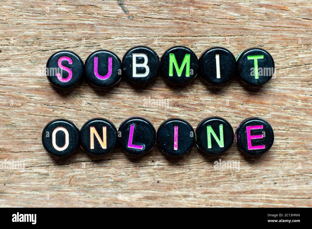 Black bead with color letter in word submit online on wood background ...