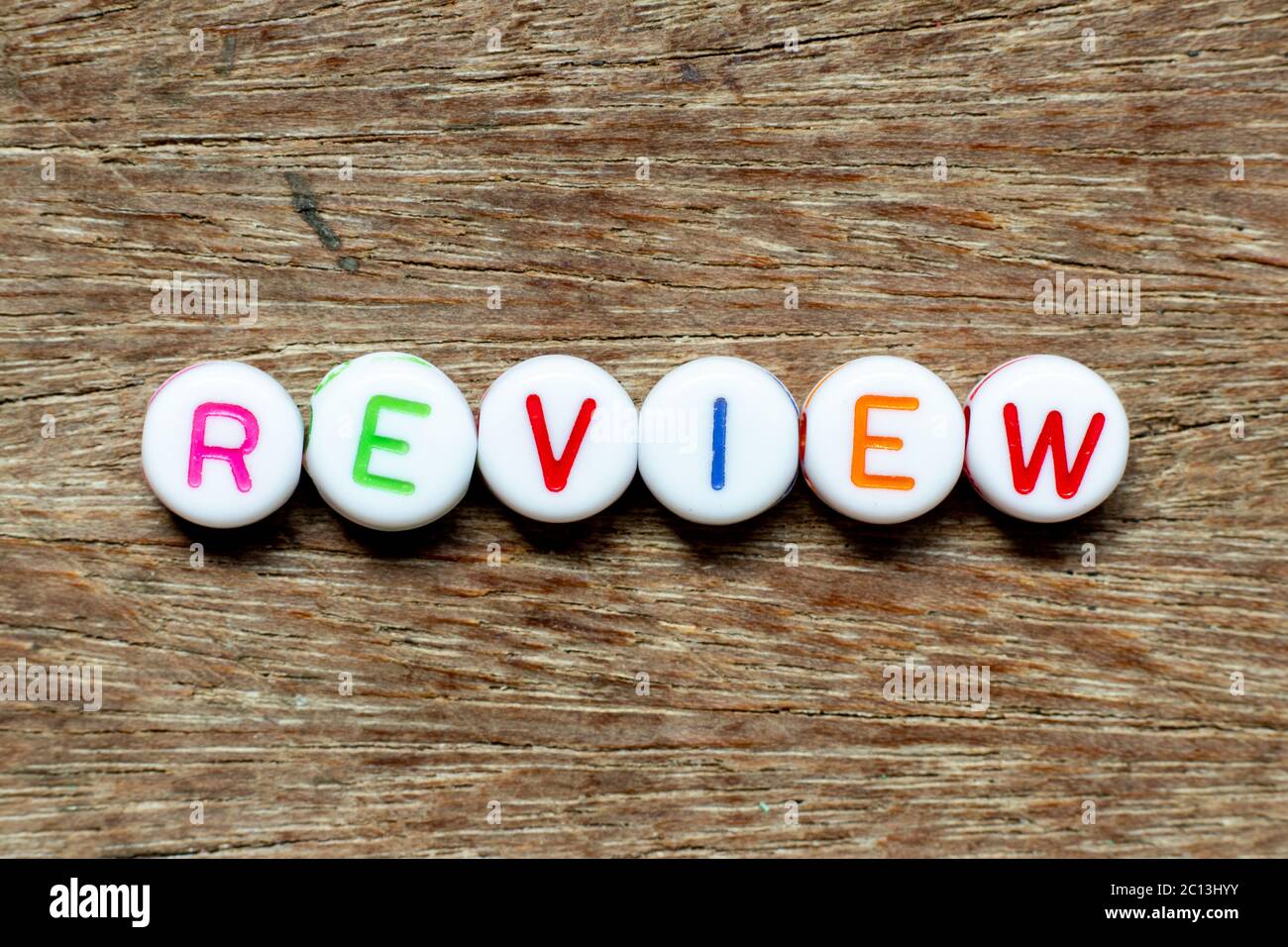 White bead with color letter in word review on wood background Stock ...