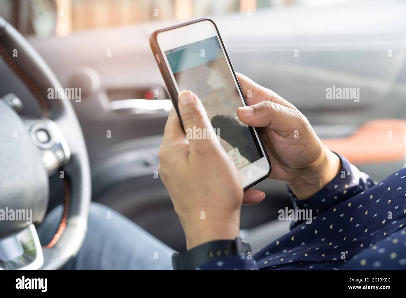 Holding mobile phone in car to communication with family and friends ...