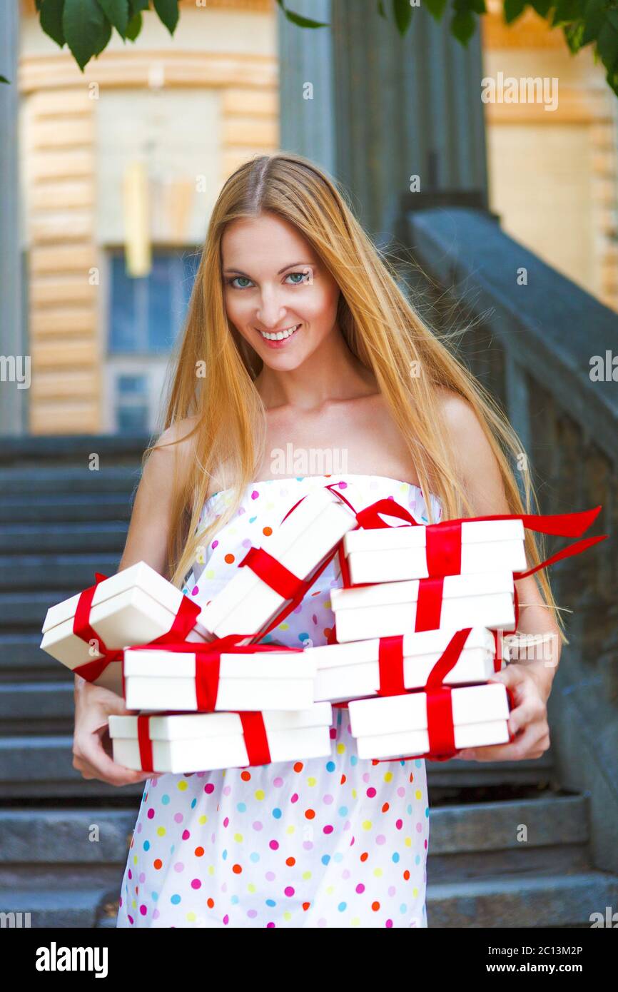 Gift boxes in the hands of young blond woman Stock Photo - Alamy