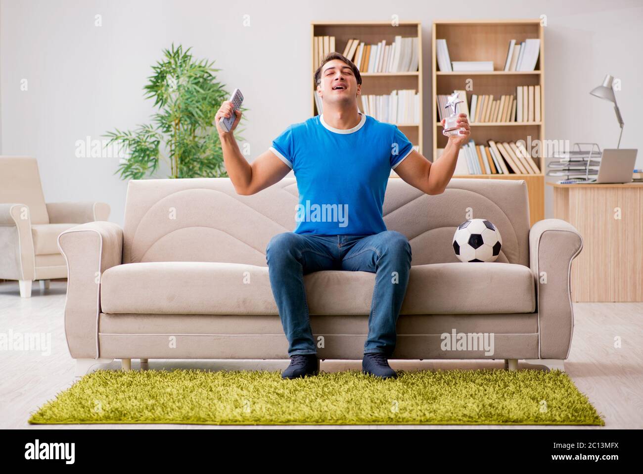 Man watching football at home Stock Photo - Alamy