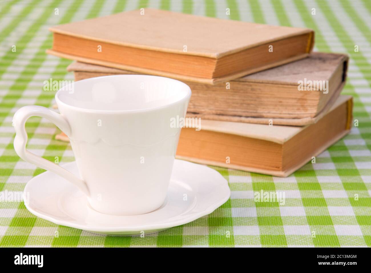 Cup with books on the table Stock Photo - Alamy