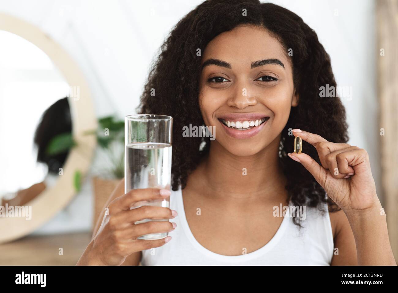 Vitamins And Food Supplements. Smiling Black Woman Holding Omega-3 Capsule And Water Stock Photo ...