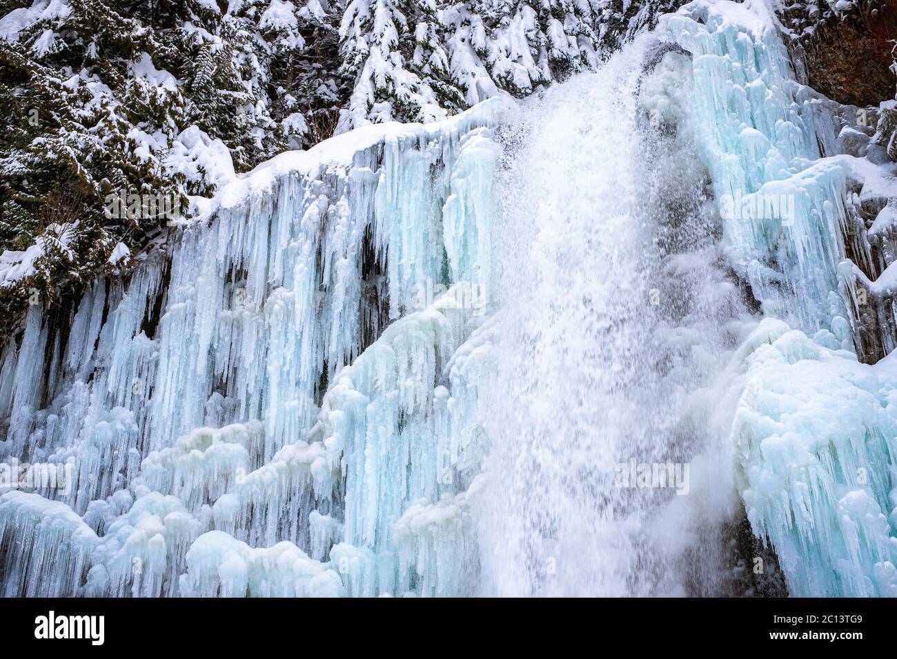 Zoomed in look at icy river flowing over rocky cliff edge Stock Photo ...