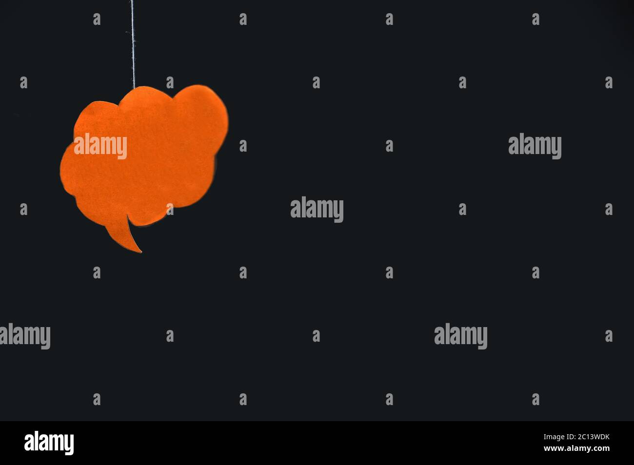 orange call out hanging with some parts in focus against black ...