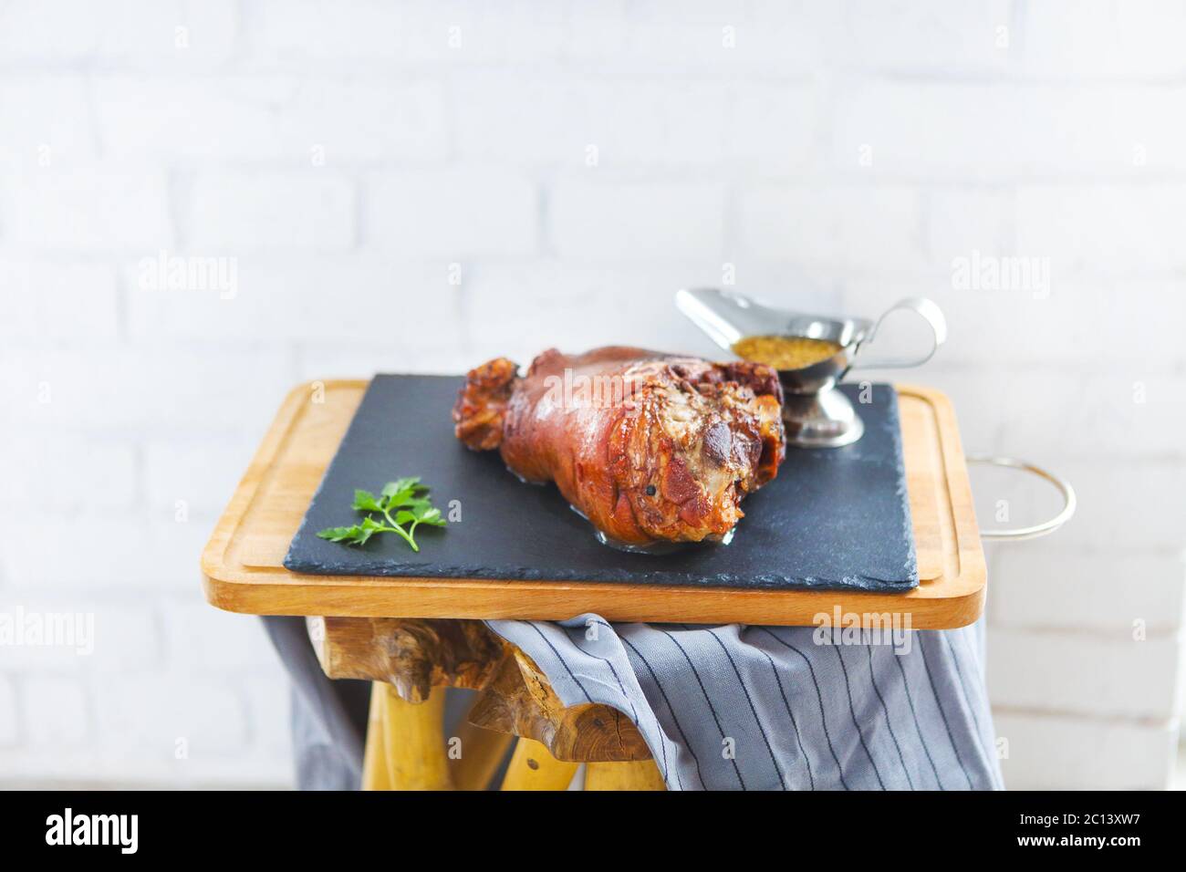 Roasted pork leg (rulka) served with garlic sauce on the wooden table ...