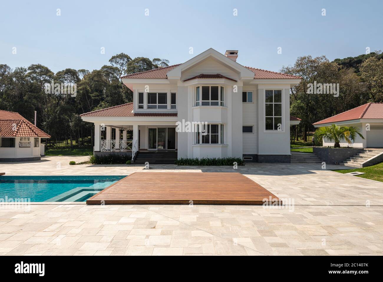 exterior view of a house with swimming pool and moving deck at front ...