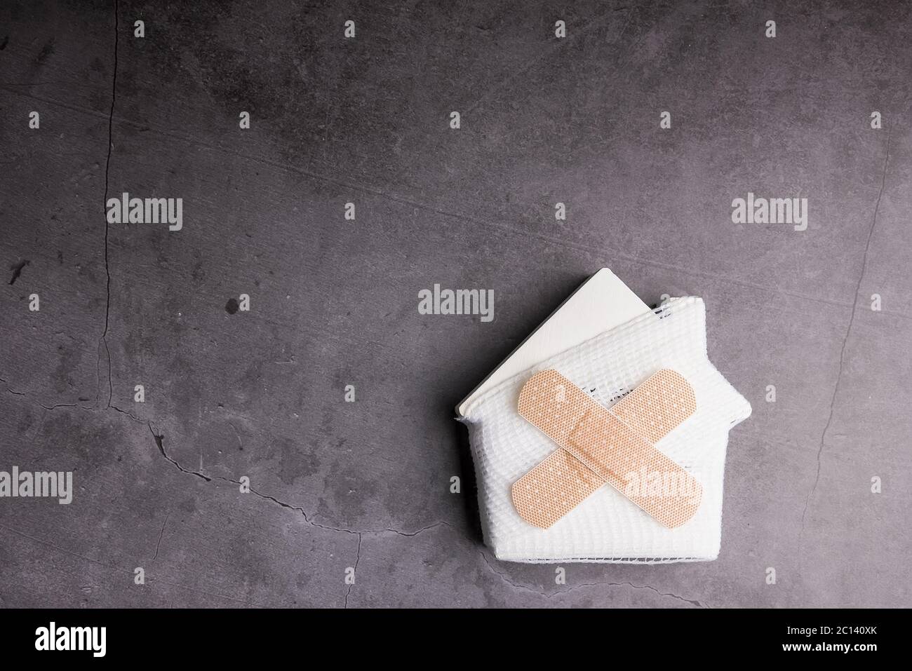 Wooden model white houses and first aid equipment on a cement gray ...