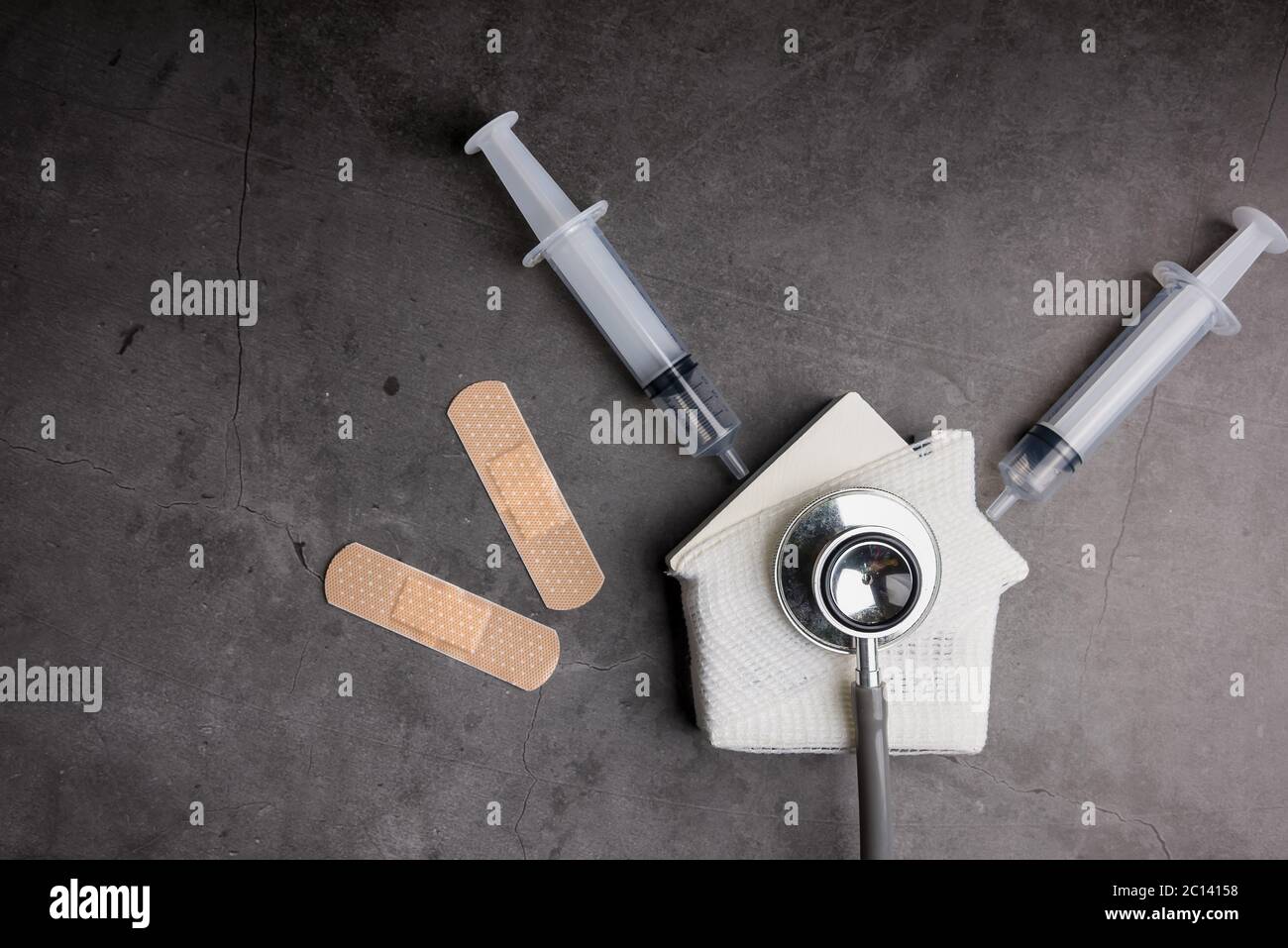 Wooden model white houses and first aid equipment on a cement gray ...