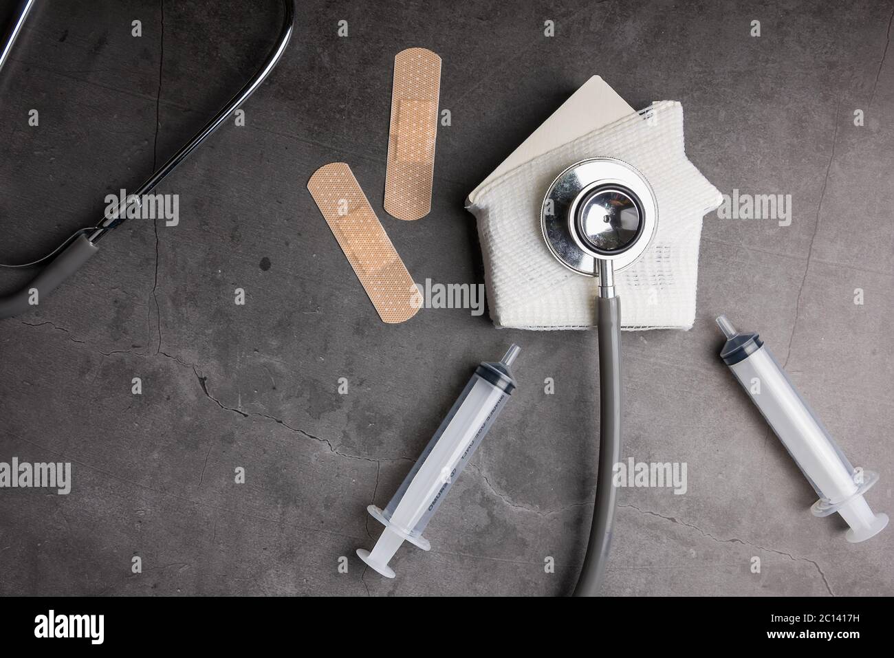 Wooden model white houses and first aid equipment on a cement gray ...