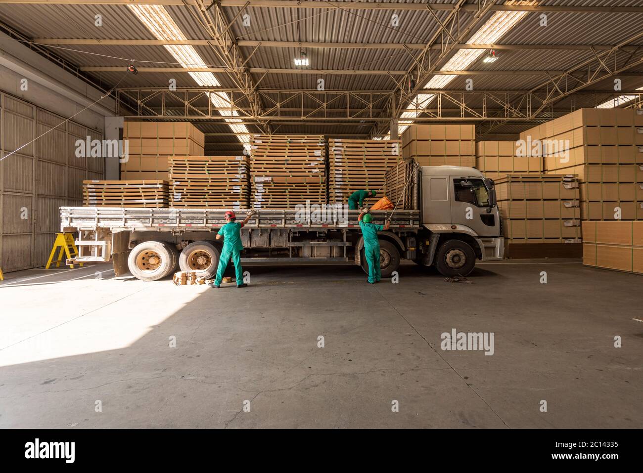 men loading truck on factory floor shed with mdf pine wood sheets Stock ...