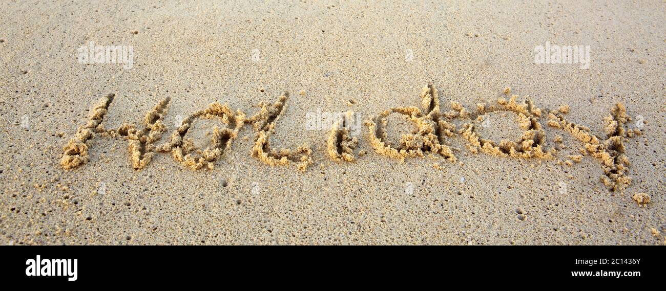 Holiday Written in sand at the beach Stock Photo - Alamy