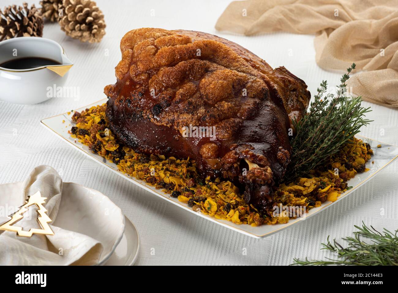 roasted pork shoulder ham meat on a white platter with dishes napkin ...