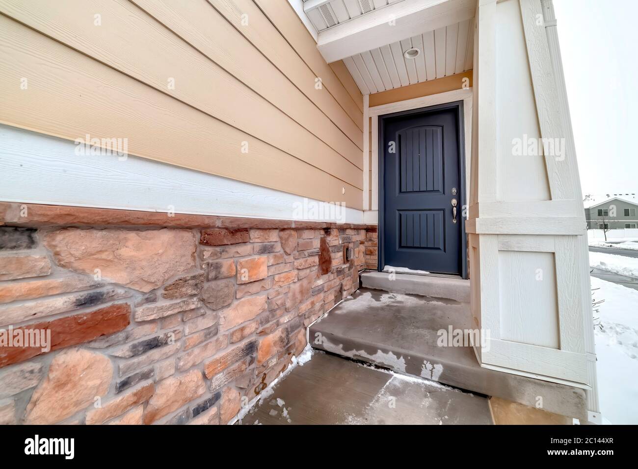 Home entrance with blue panel door and wall with stone bricks and wood ...