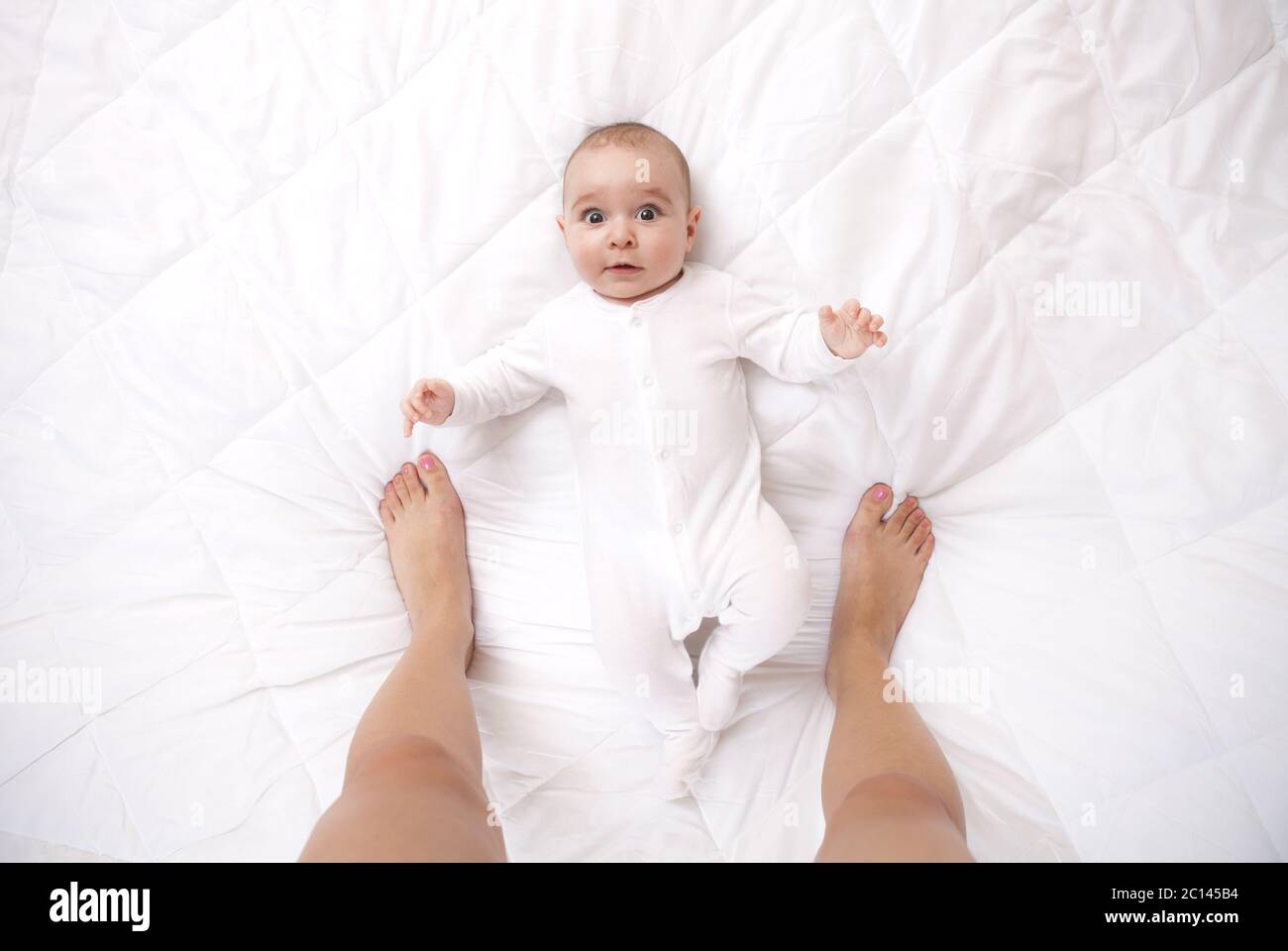 Happy addorable baby boy and the legs of his mother Stock Photo - Alamy