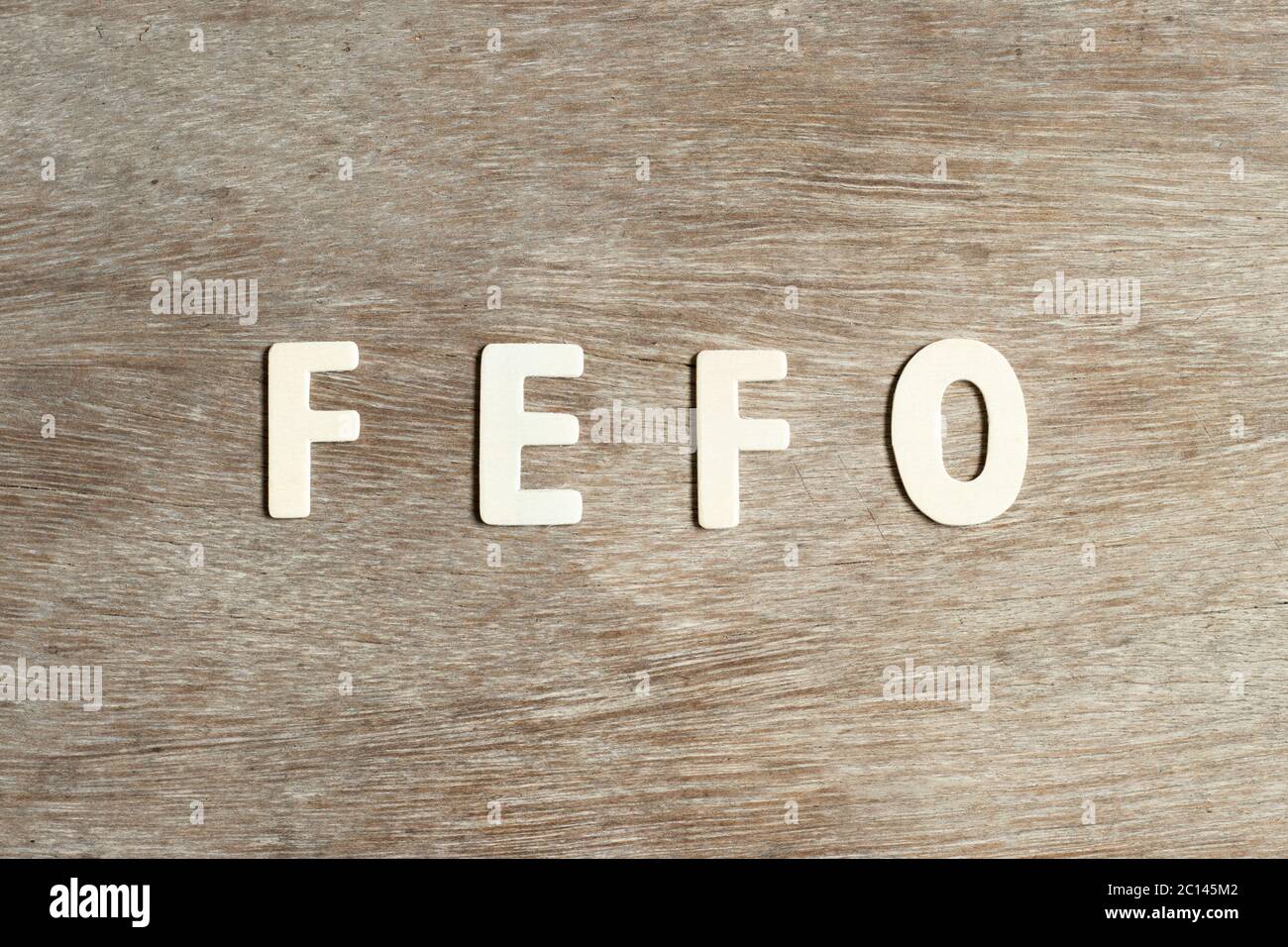 Alphabet letter in word FEFO (first expired first out) on wood ...