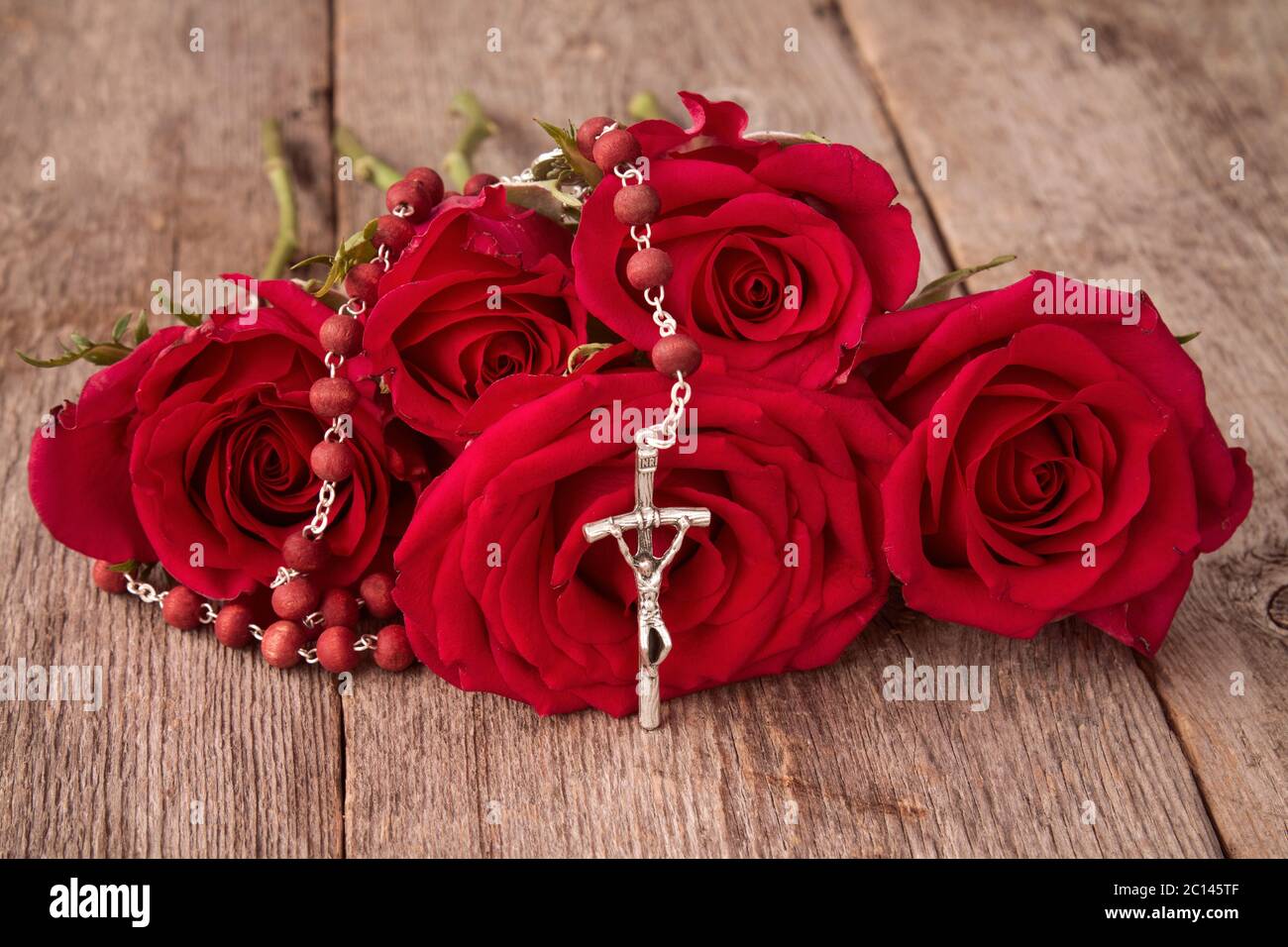 Rosary and bunch of red roses Stock Photo - Alamy