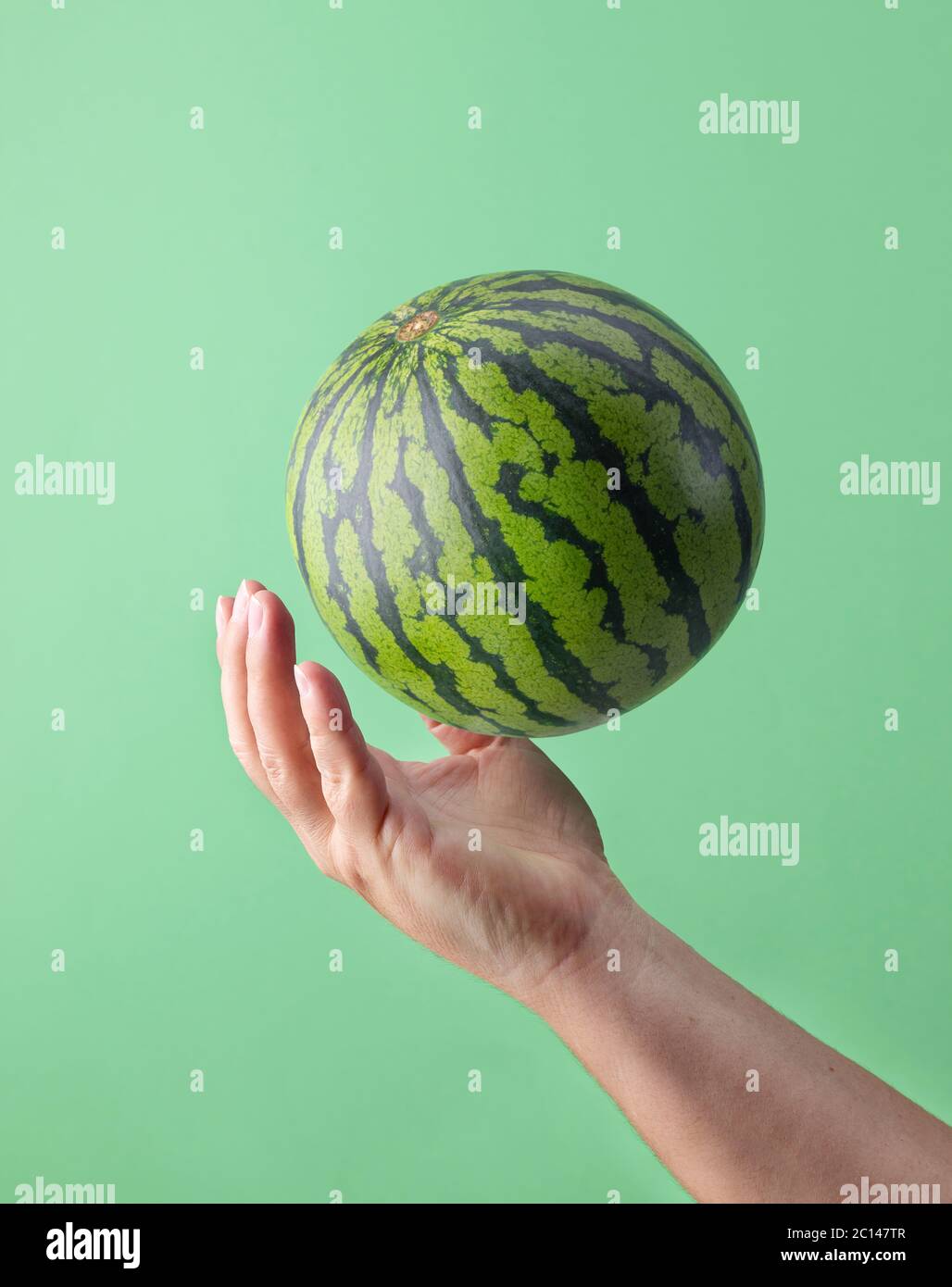 watermelon and human hand isolated on green background Stock Photo - Alamy