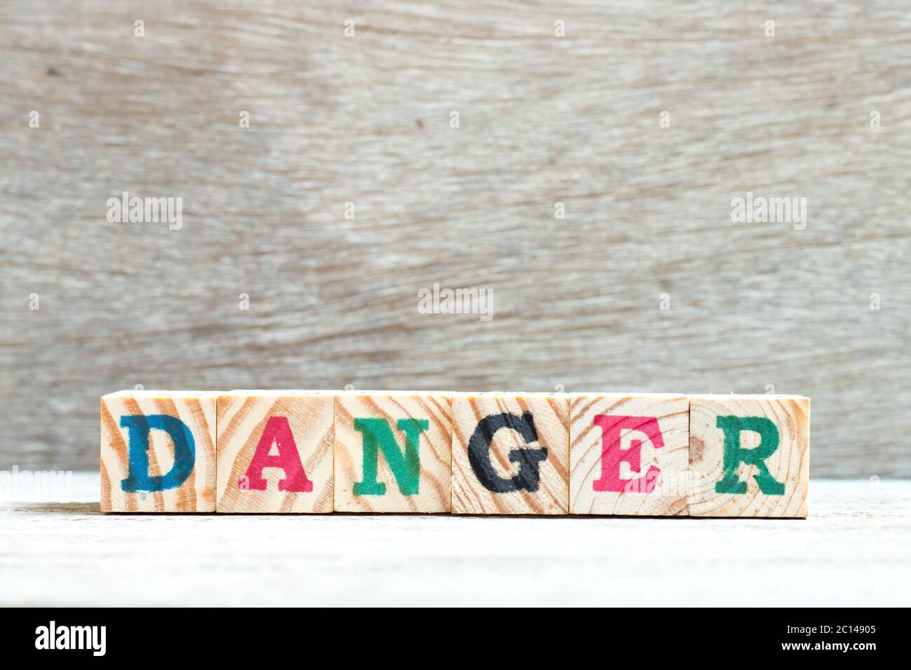 Alphabet letter block in word danger on wood background Stock Photo - Alamy