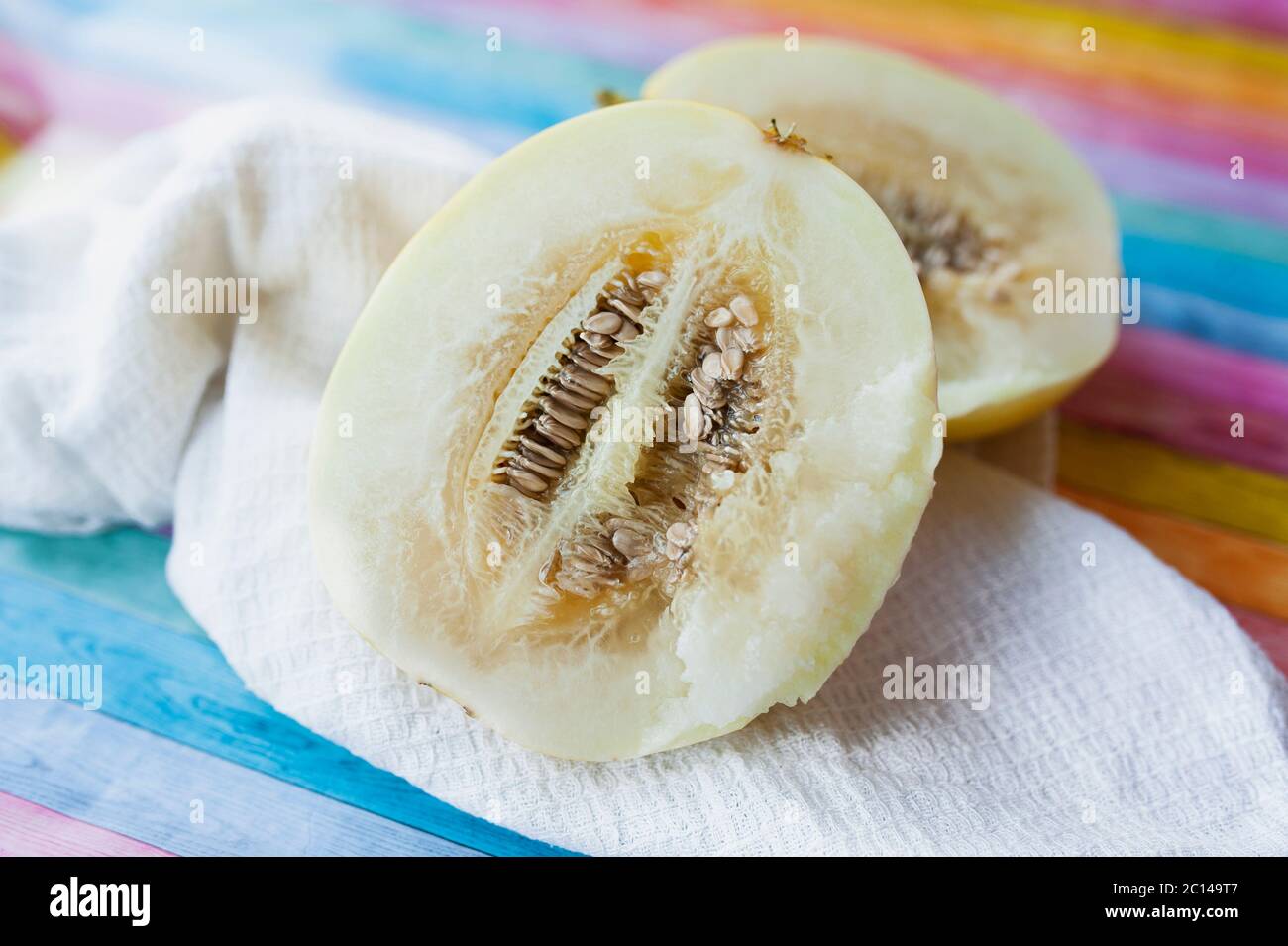 ripe juicy little yellow melon in drops of clear water with bones cut ...